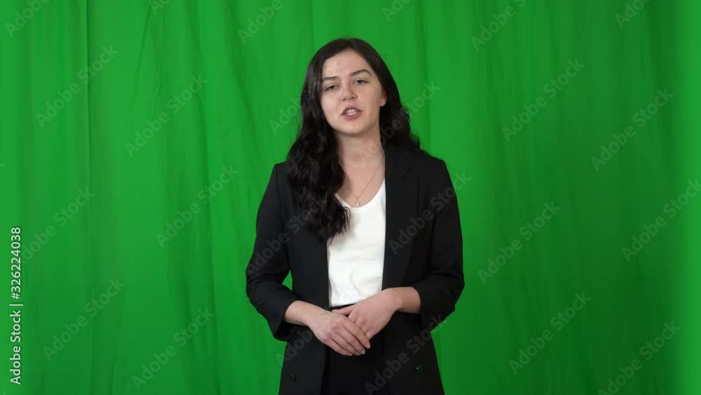 Beautiful brunette girl talking to the camera. Background - green ...