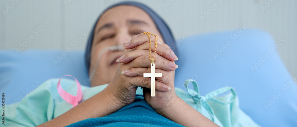 christian cross in hands of cancer patient wearing headscarf during ...