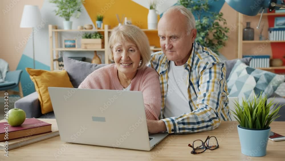 Vidéo Stock Elderly couple man ans woman are using computer at home ...