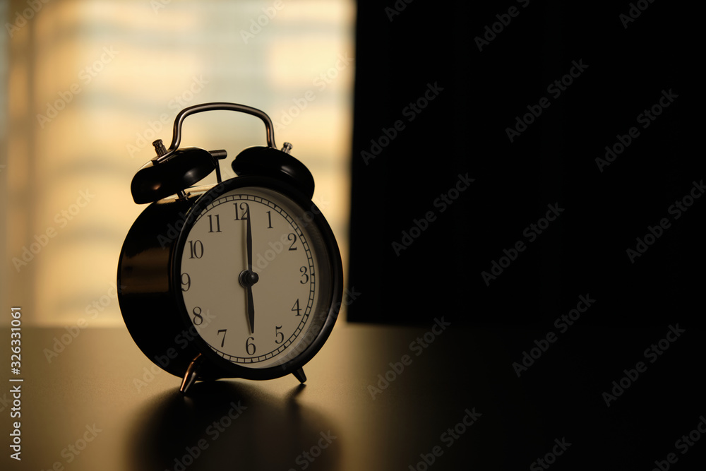 Black vintage alarm clock on black table in the room that have early ...