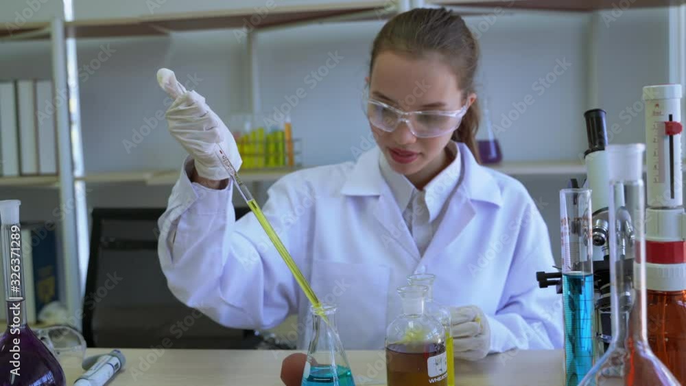 Scientists use pipette to suck liquid and drip onto graduated cylinder ...
