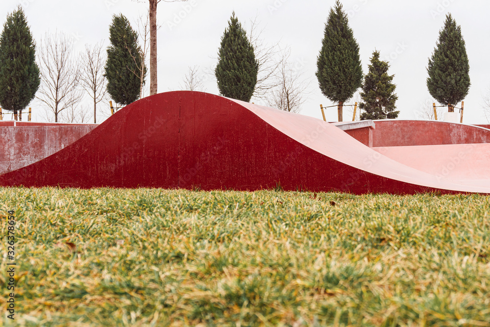 a red playground in the shape of a ramp for skateboards, rollers and ...