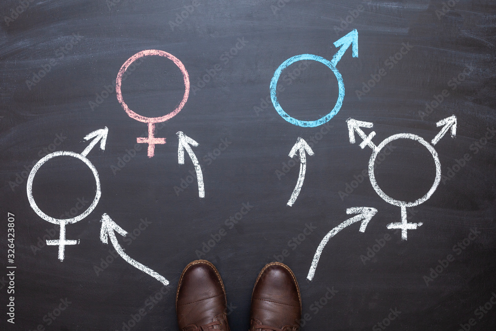 A man standing before a choice of gender symbols of male, female ...