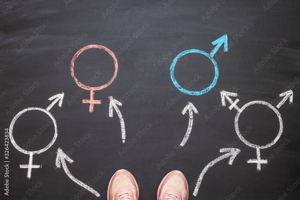 A girl standing before a choice of gender symbols of male, female ...