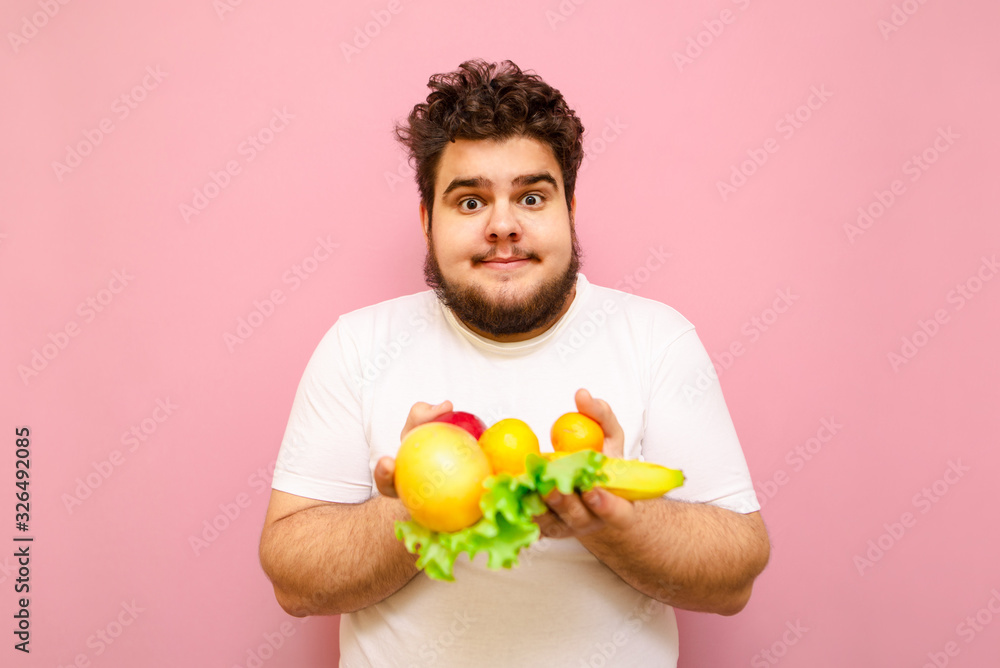 Funny guy with overweight and beard stands on a pink background with ...