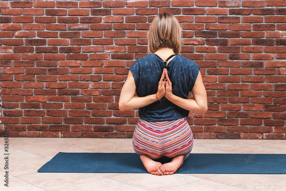 Woman working out in loft interior on brick wall background with copy ...