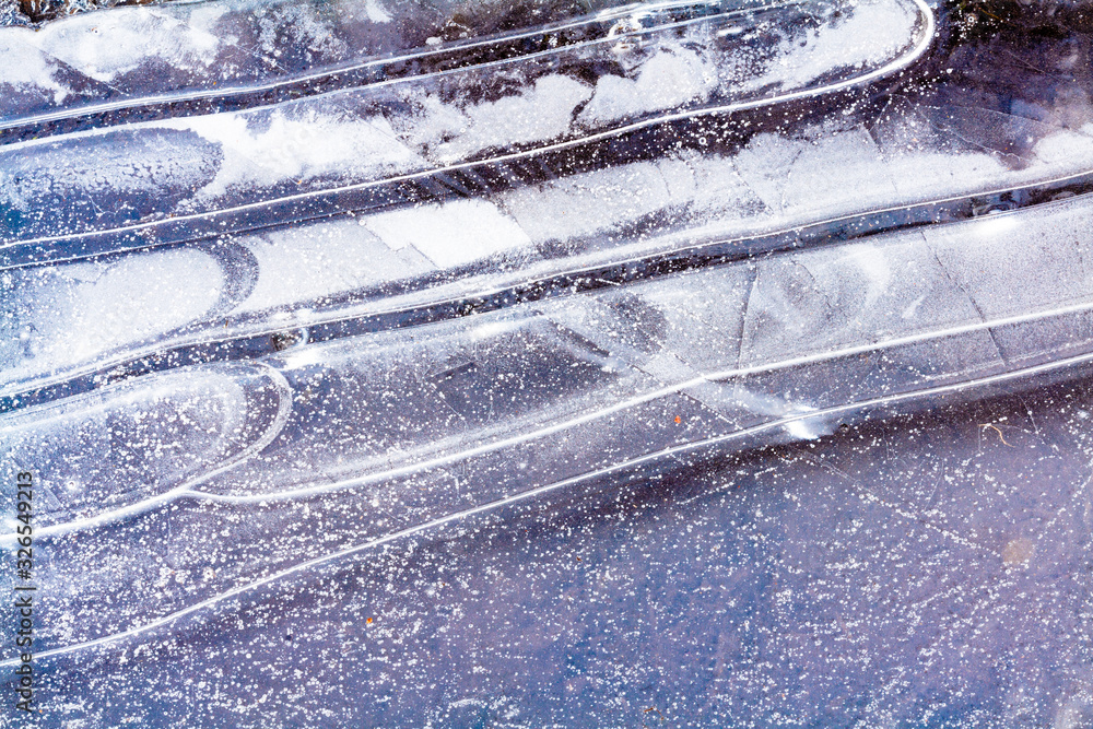 Ice with air bubbles and fancy fault lines, covered with snow in places ...