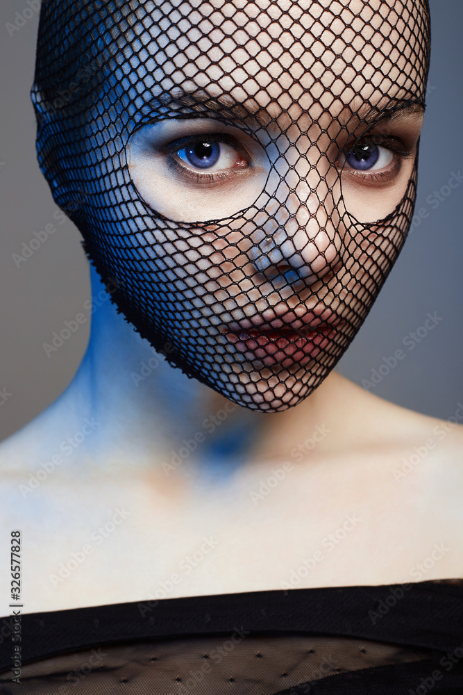 Beautiful Woman in Net Mask lighted in blue Stock Photo | Adobe Stock