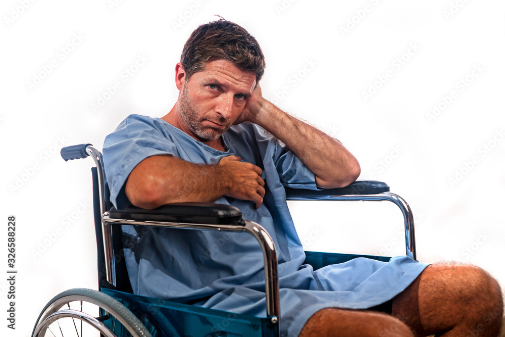 young depressed and frustrated injured man in hospital patient gown ...