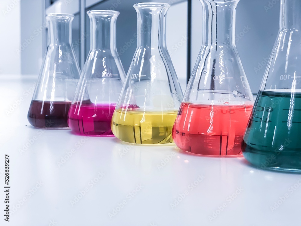 The Erlenmeyer or Conical flask on bench laboratory, with colorful ...