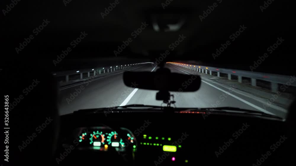 The driver rides at night on a lighted road. The car cracks and ...