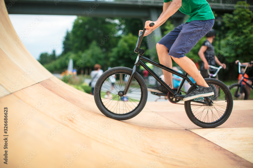 Bmx rider jumping over on a U ramp in a skatepark (motion blurred image ...