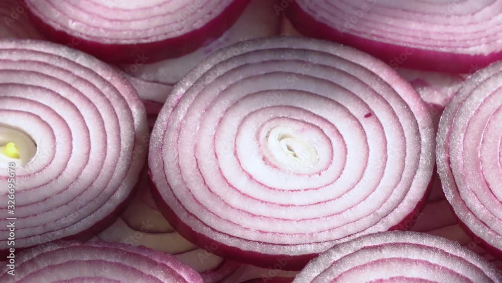 Vidéo Stock Sliced red onion rings rotating in 4K. Closeup top view of ...