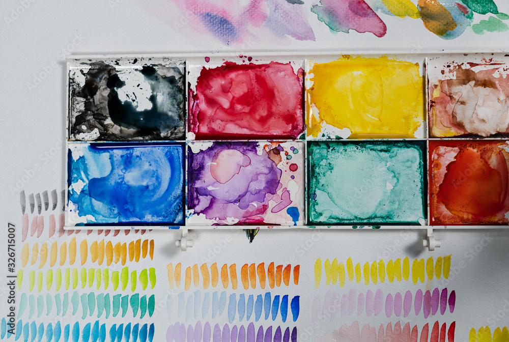 Artist watercolour paint palette with mixed and blended colour tests ...