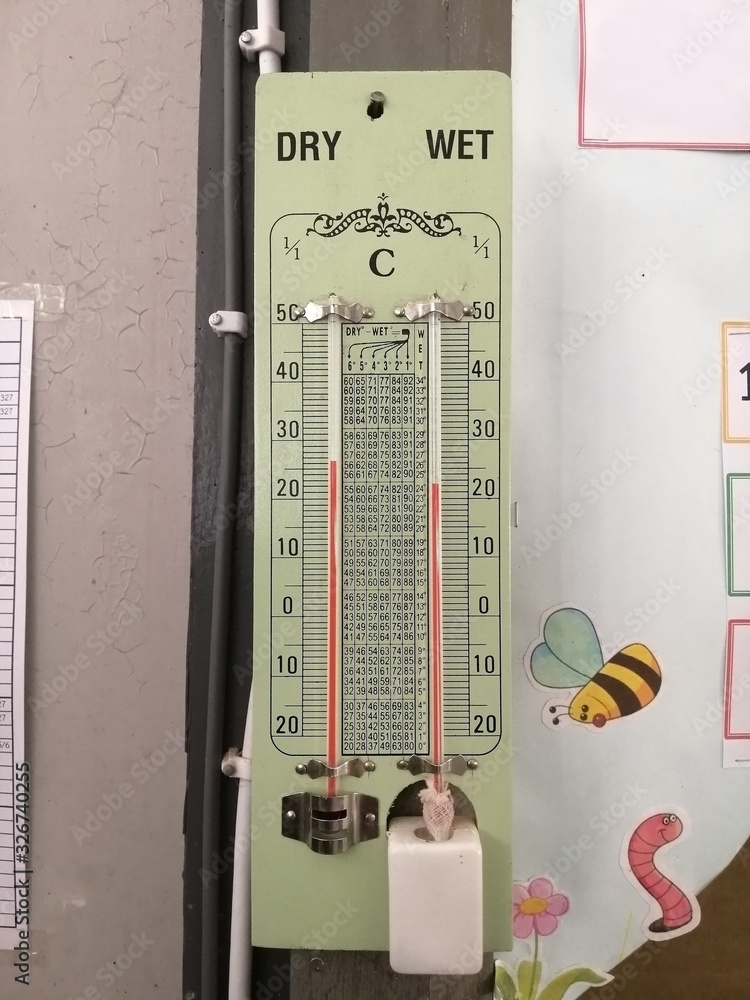 dry and wet bulb hygrometer is hung on the wall of the classroom ...