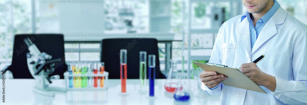 Male Research Scientist write a short note and working in laboratory ...