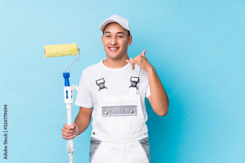 Young professional painter latin man isolated showing a mobile phone ...