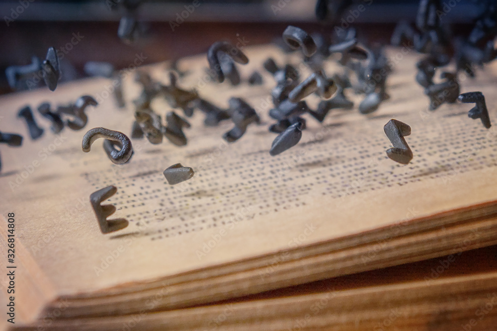 open book with falling black letters Stock Photo | Adobe Stock