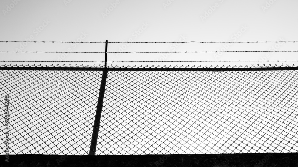 Barbed wire prison fence black and white background. Jail yard wall and ...