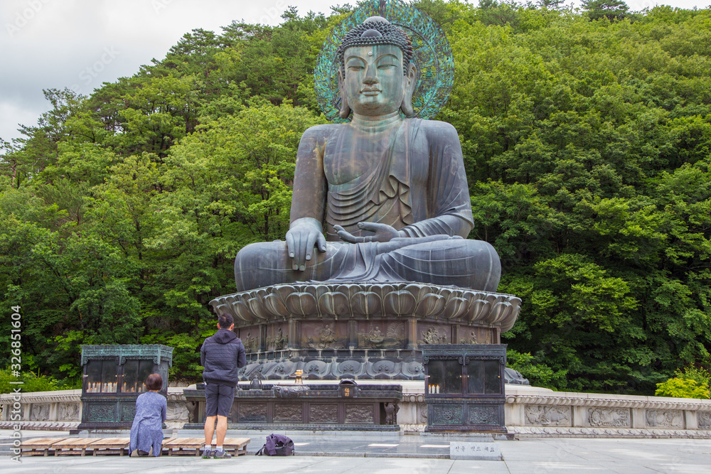 Asia Chinese tourist pray at the huge Buddha in the Sinheungsa Temple ...