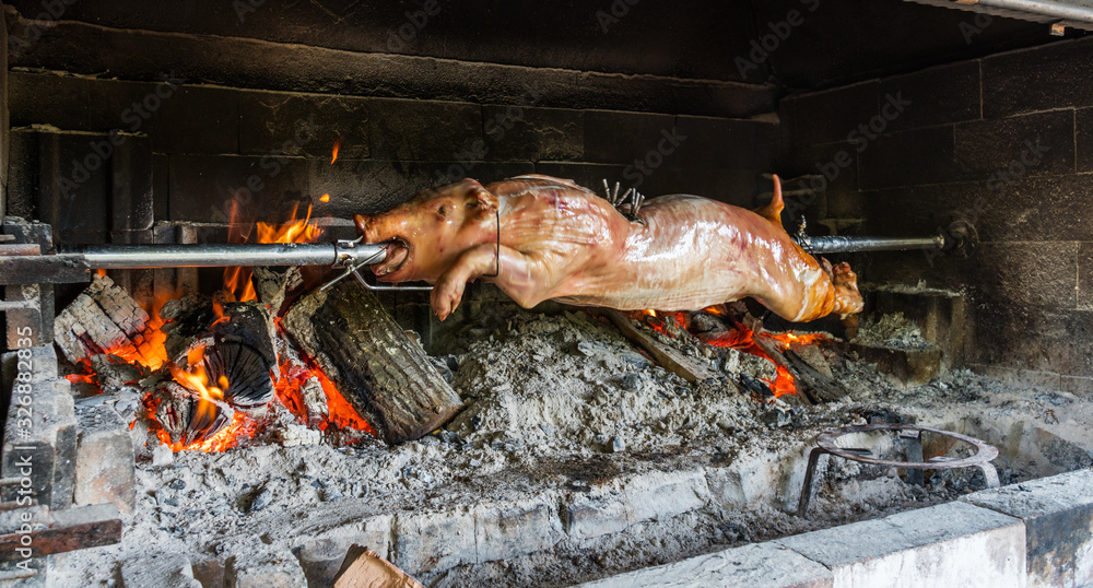 Suckling pig is roasted on a spit over open fire on stove. Stock Photo ...