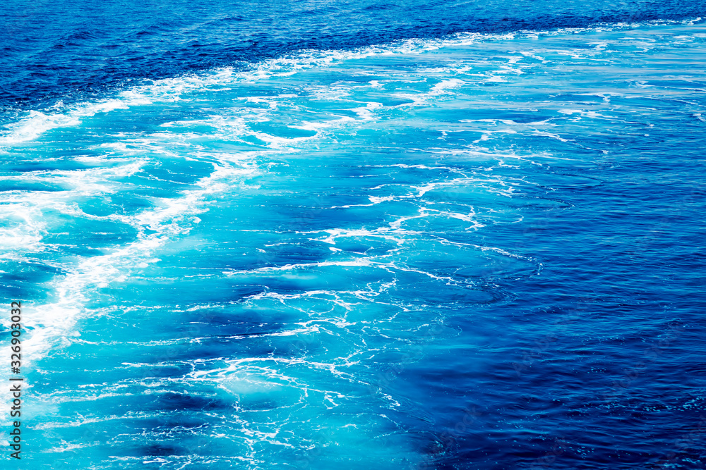 Trail on ocean water surface behind of fast moving powerful ship ...