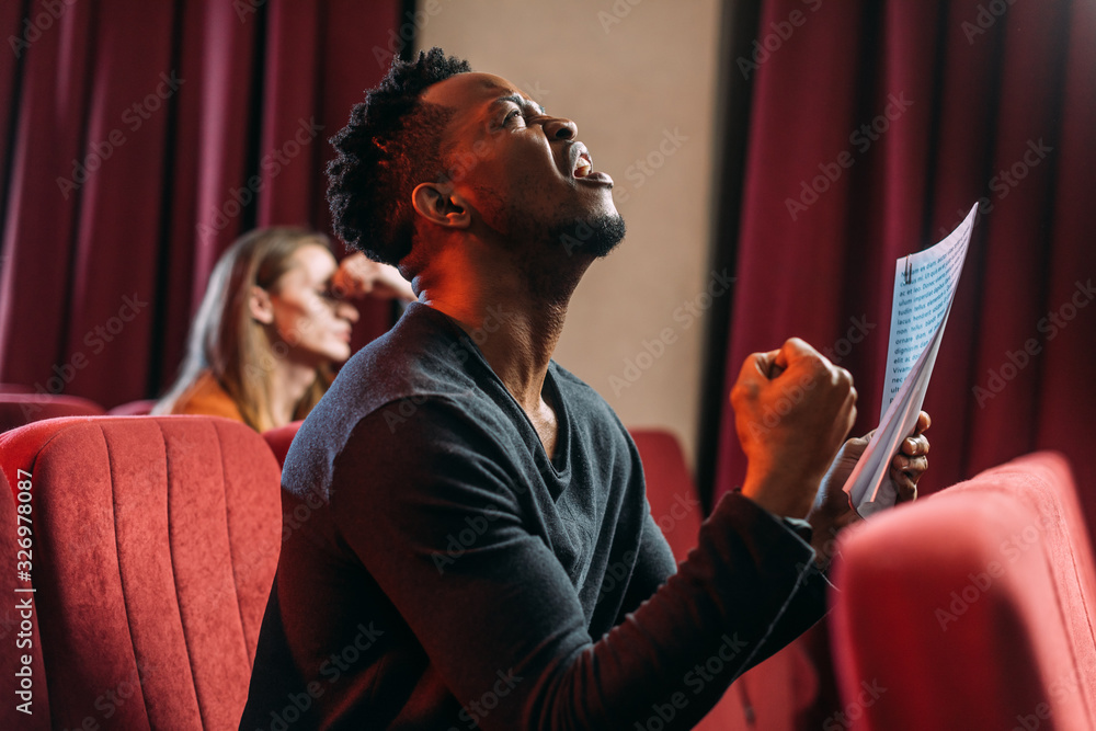african american sad actor shouting and rehearsing in theatre with ...