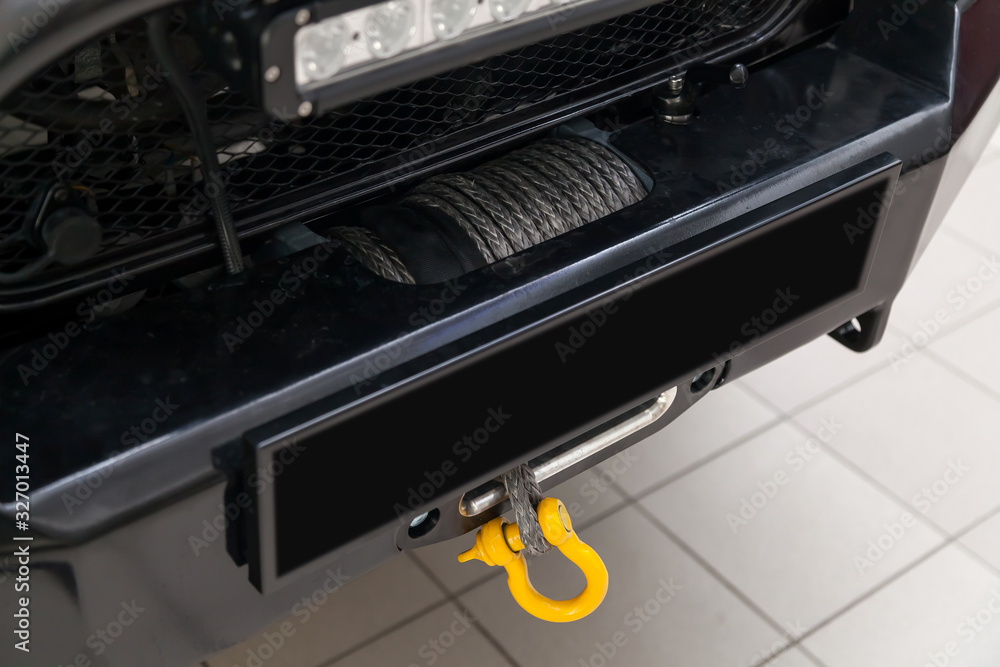 A towing winch with a shackle and a loop on a metal cable mounted on a ...