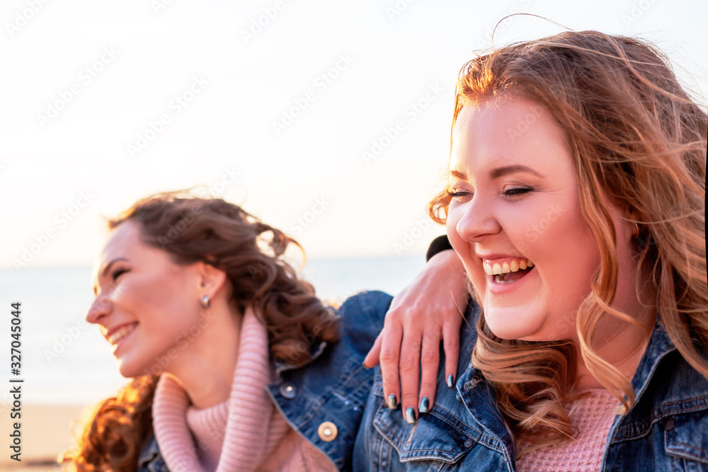 Back view of two freinds , plus size with thin girls walking on the ...