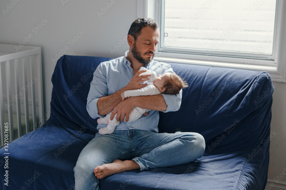Middle age Caucasian father feeding newborn baby from bottle milk. Man ...