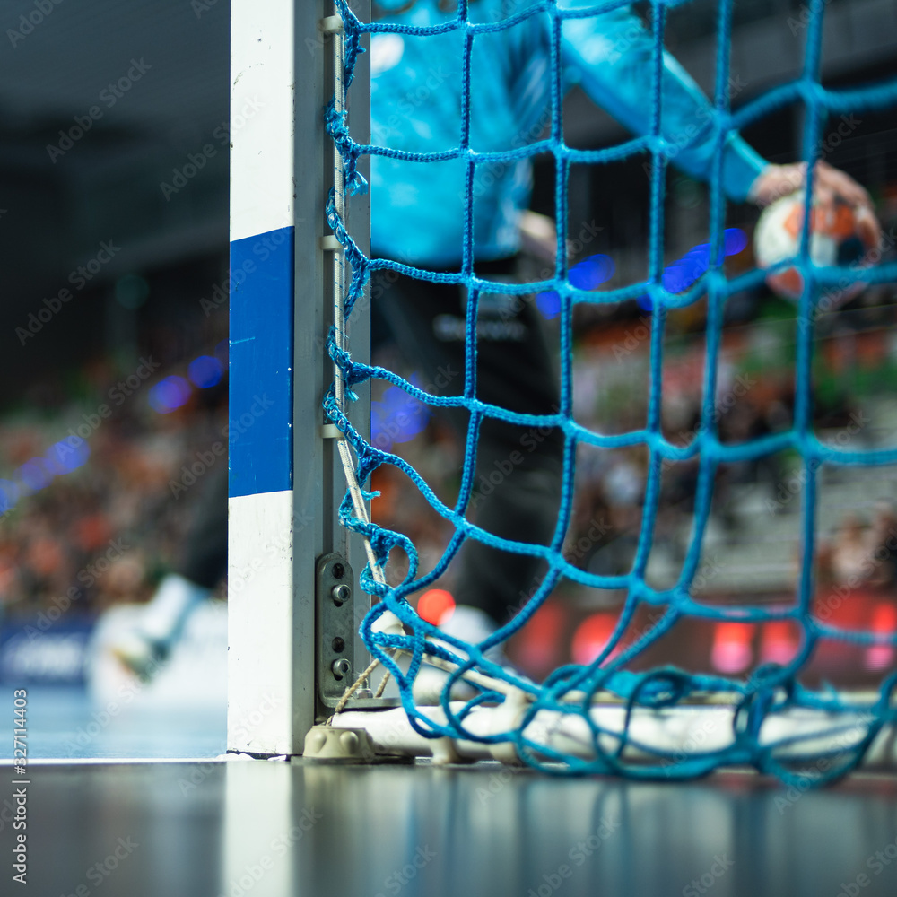 Detail of handball goal post with net and handball match in the ...