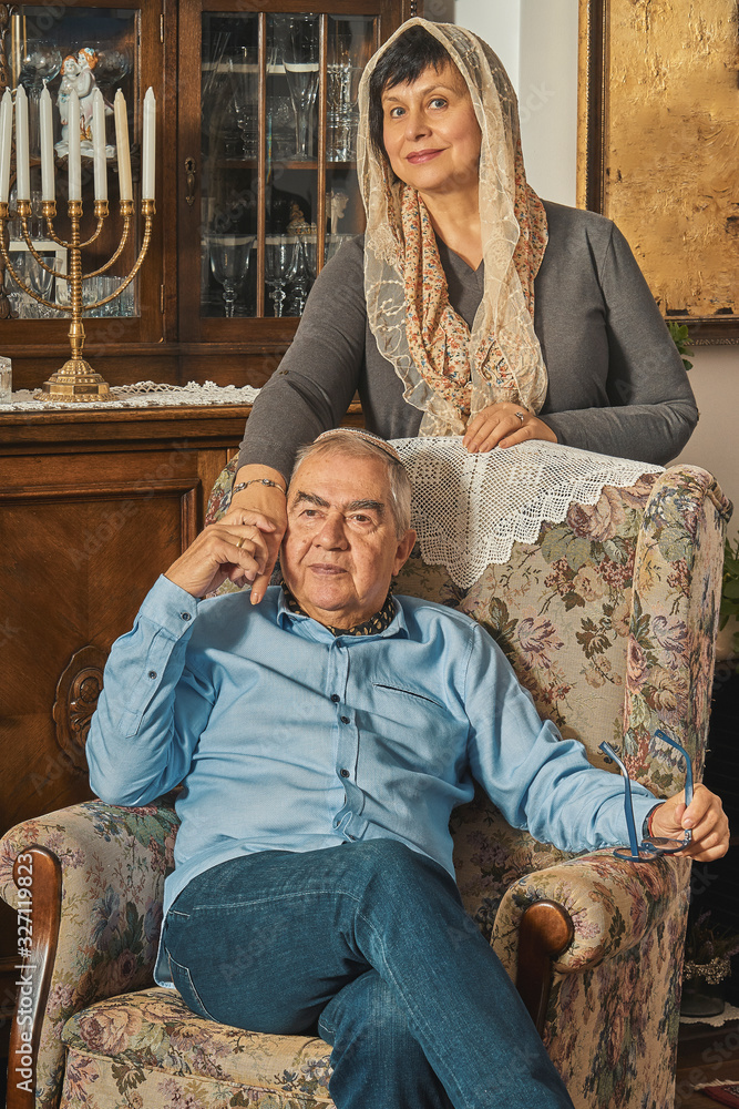 Foto de Jewish senior couple poses on armchair in traditional home do ...