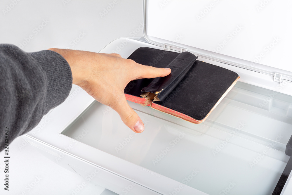 Man photocopying, scanning an old book on an open photocopier home ...