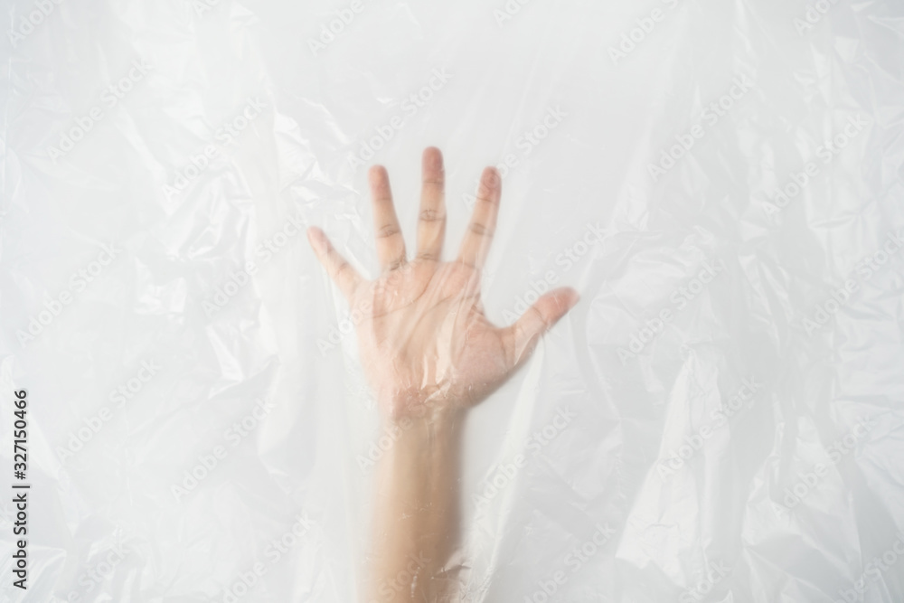 Hand pushing behind the plastic sheet on white background. Stop using ...