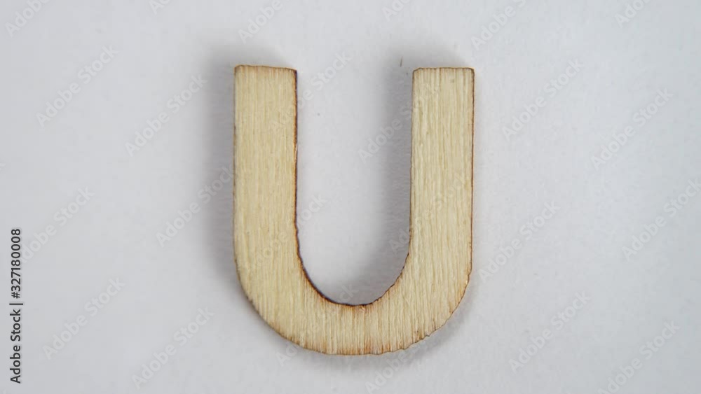 Letter U of the English alphabet in motion. Wooden letter moves on a ...