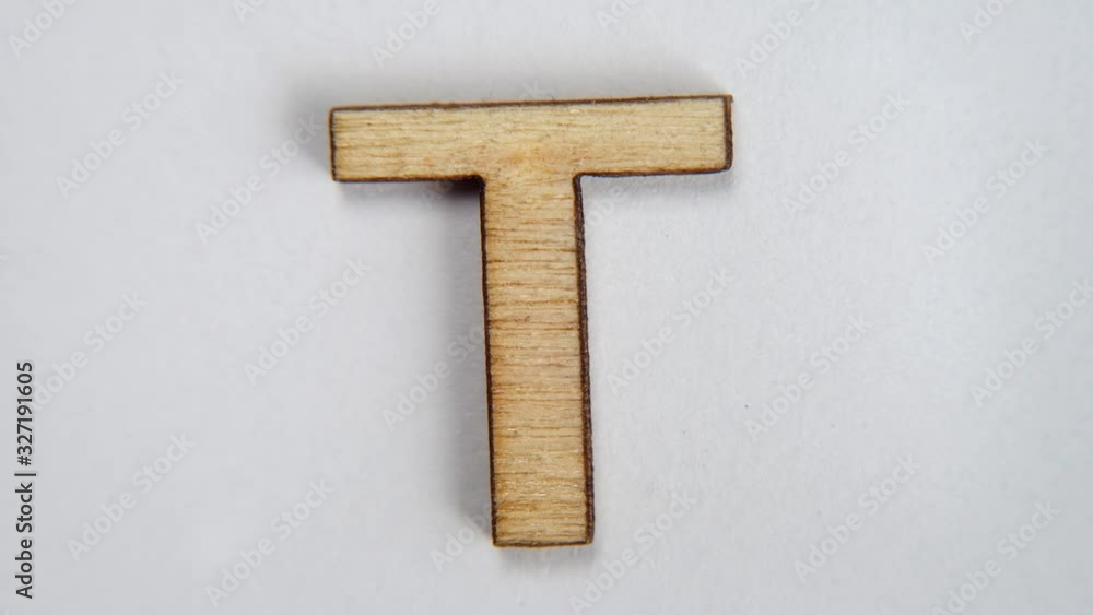 Letter T of the English alphabet in motion. The wooden letter is moving ...
