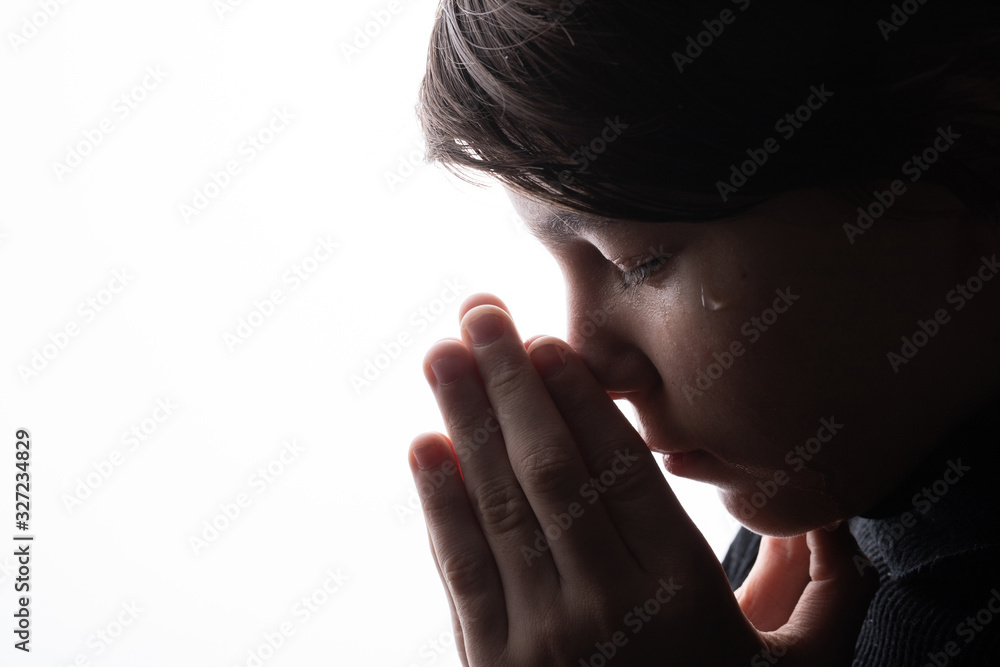 Young sad boy crying with sad eyes. White background. Free space for ...