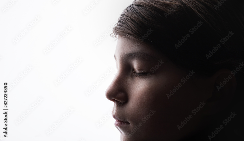 Young sad boy crying with closed eyes. White background. Free space for ...