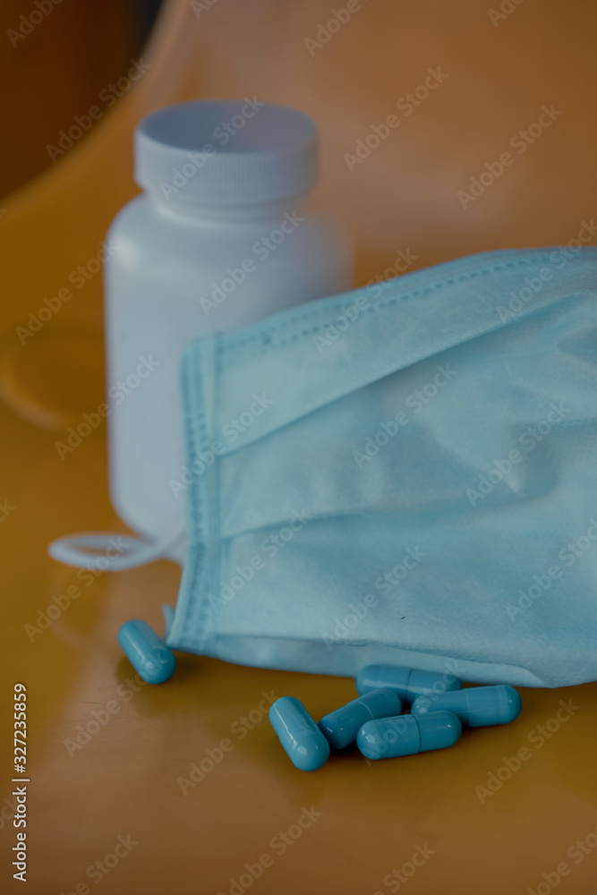 surgical mask and a bottle of medical pills against coronavirus in ...