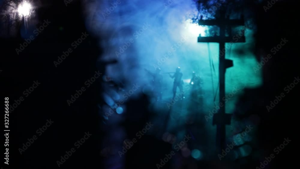 Army sniper with large caliber rifle standing in the fire and smoke ...