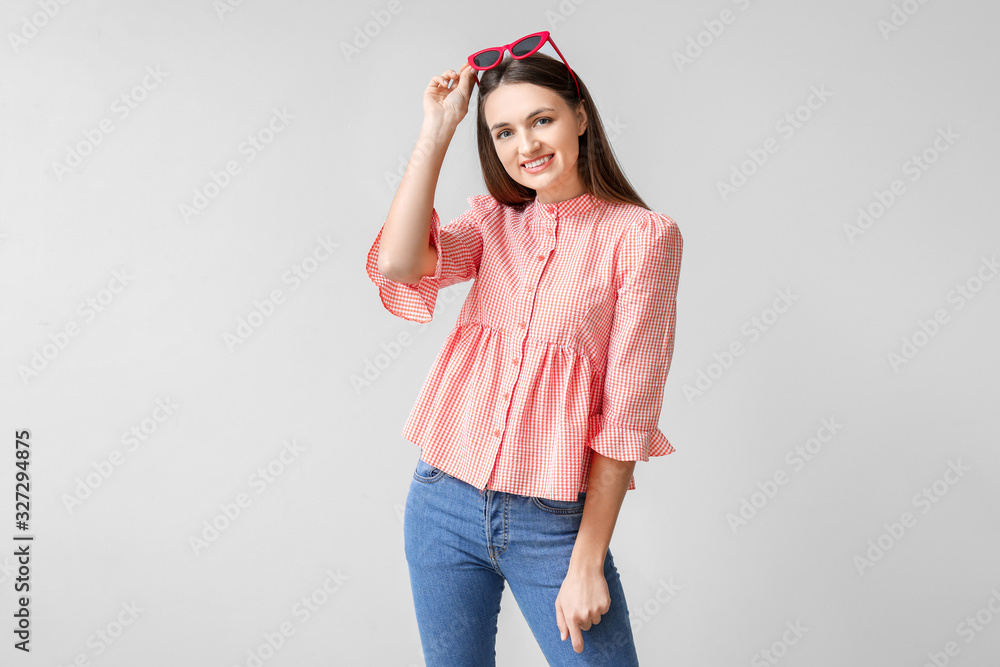 Beautiful young woman on light background Stock Photo | Adobe Stock