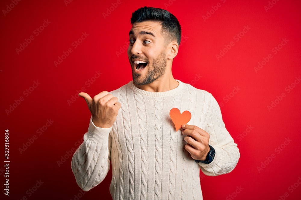 Young handsome man holding red shape heart as romantic and health ...