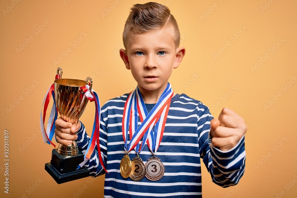 Young little caucasian kid wearing winner medals and victory award ...