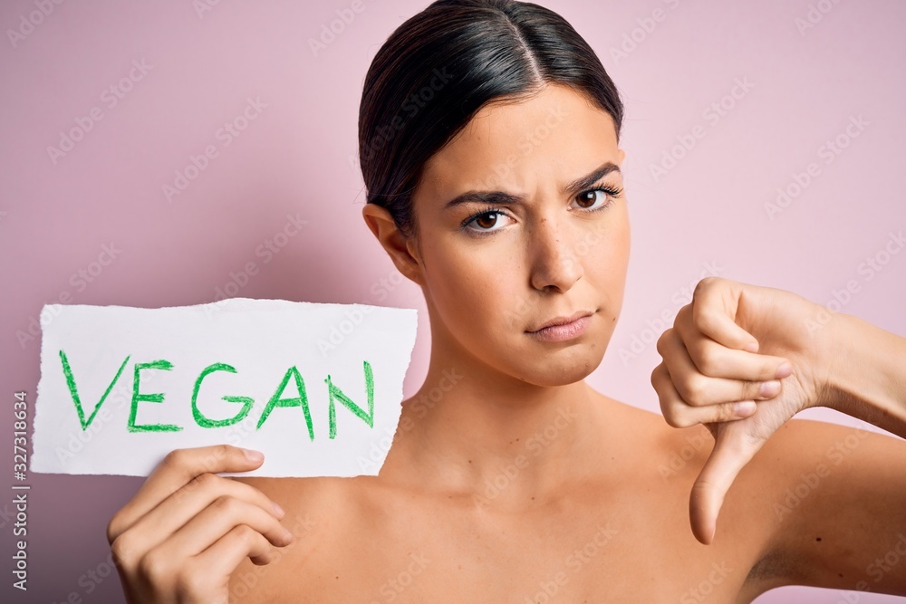 Young beautiful girl holding paper with vegan message over isolated ...
