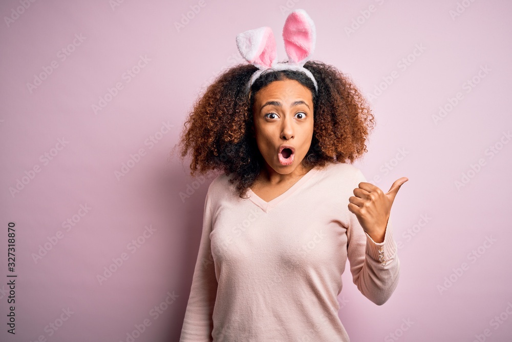 Young african american woman with afro hair wearing bunny ears over ...