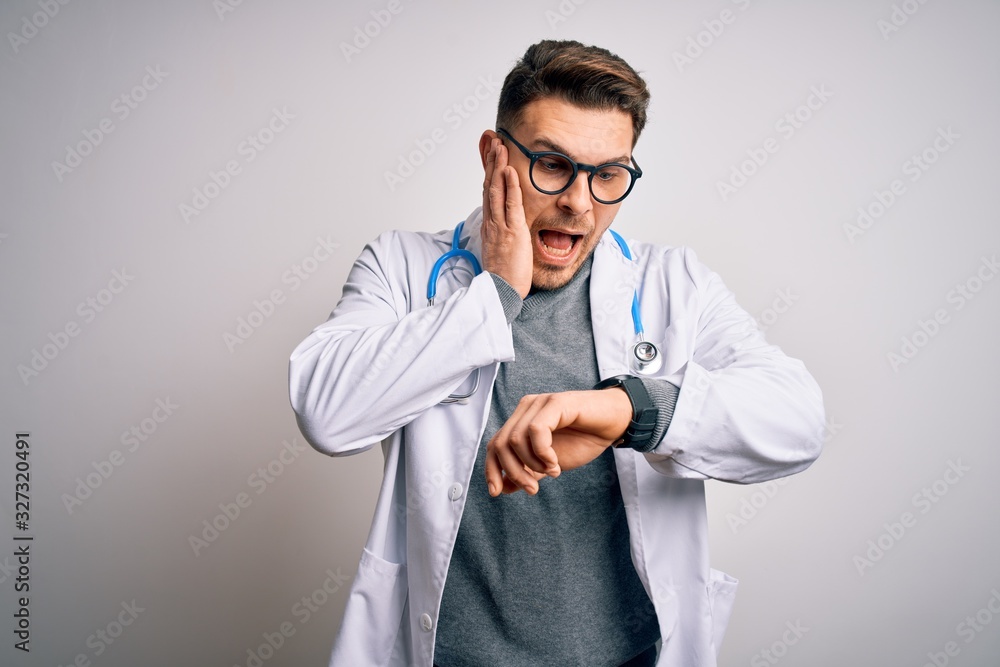 Young doctor man with blue eyes wearing medical coat and stethoscope ...