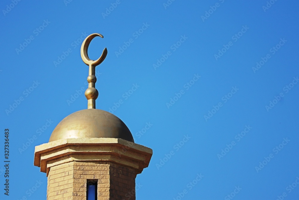 Brass or gold coloured Muslim crescent symbol on gold dome at top of ...