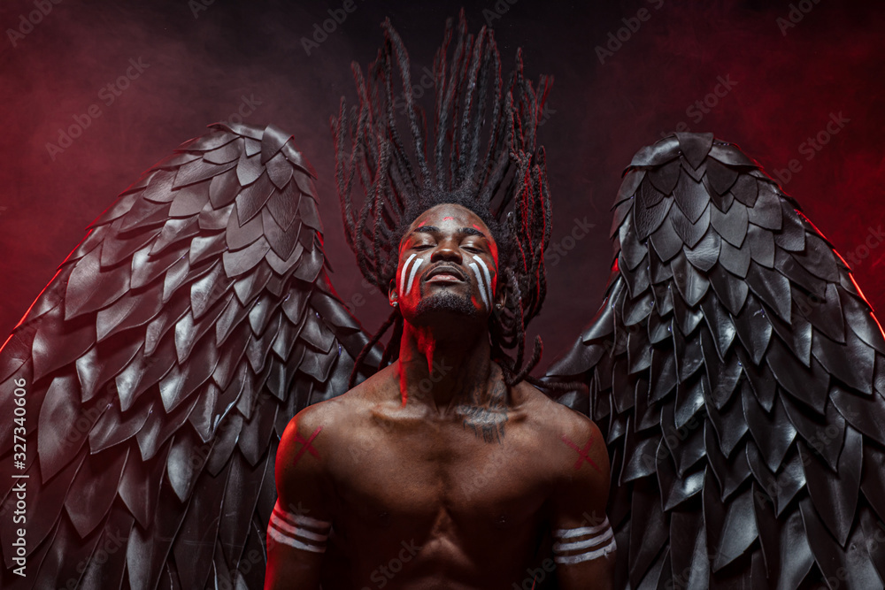portrait of reckless dark angel with strong muscles, having athletic ...