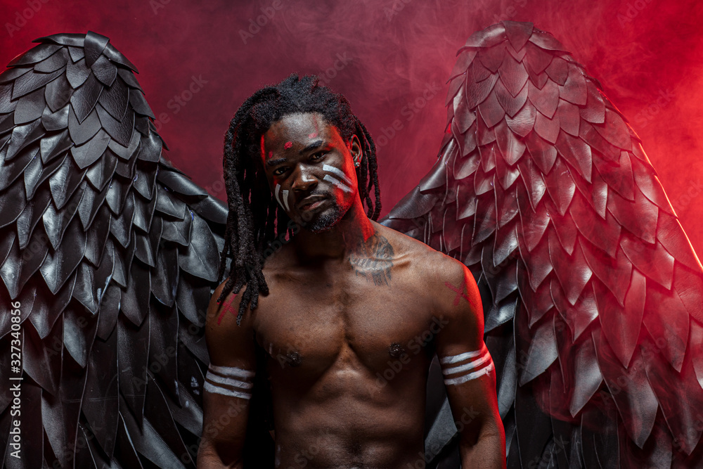 shirtless dark angel isolated in red smoky space, young muscular angel ...