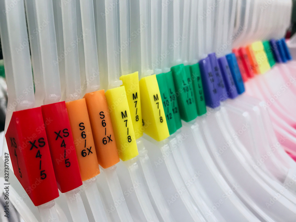 Hangers with color coded size tags in ascending order from smallest to ...
